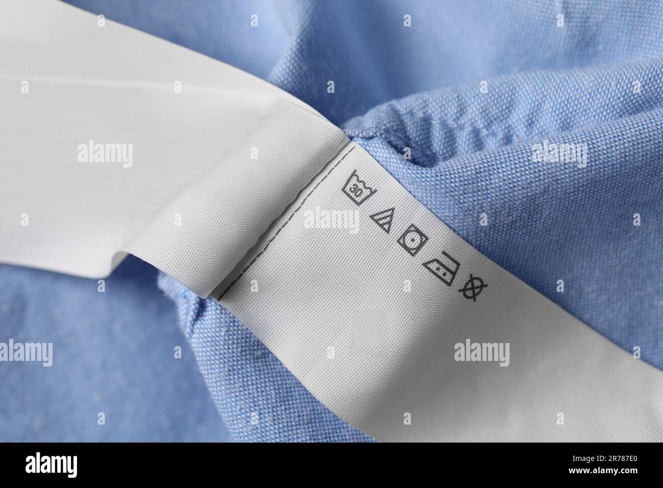 Clothing labels on light blue garment, closeup Stock Photo - Alamy