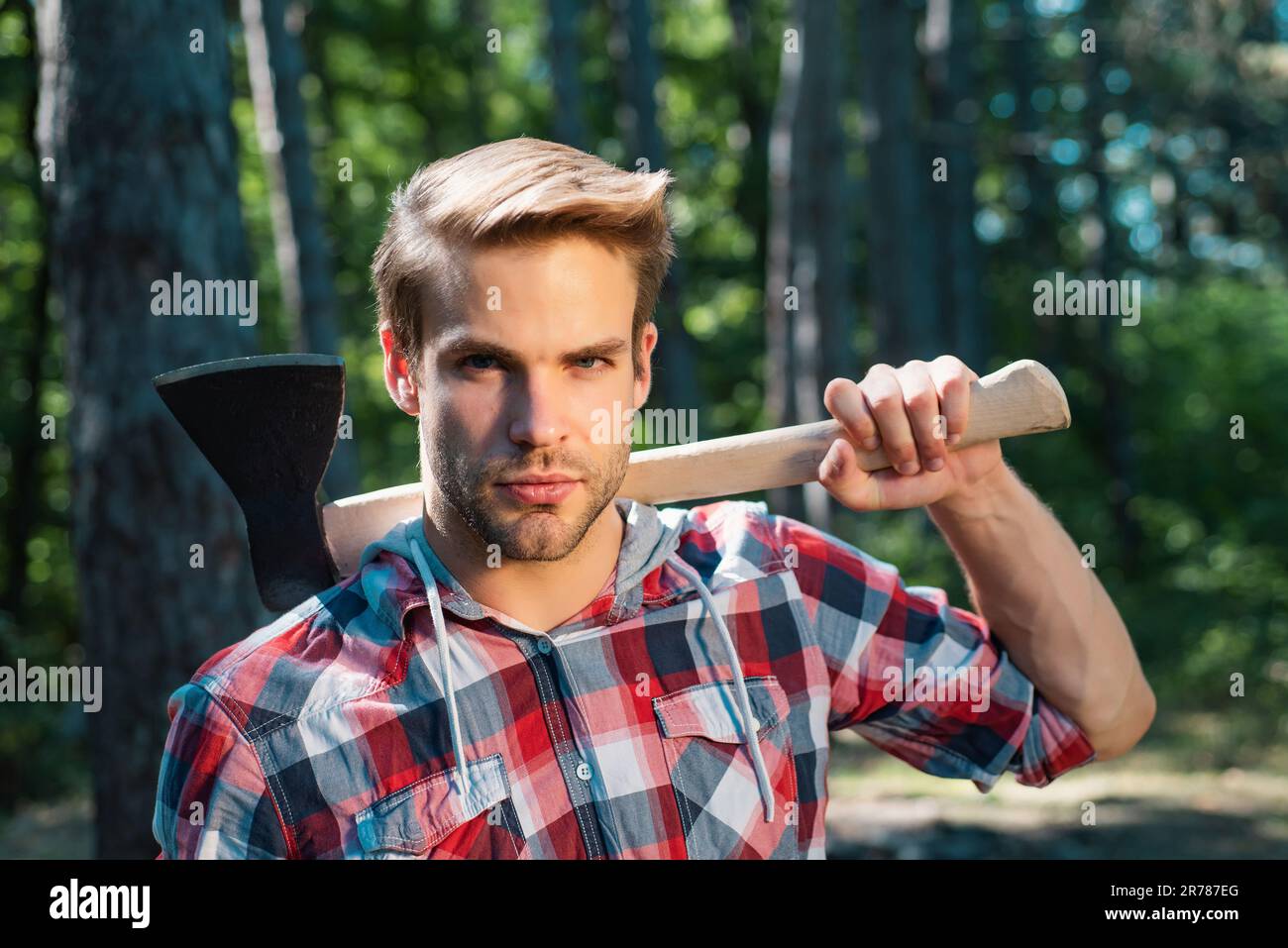 Lumberjack on serious face carries axe on shoulder Stock Photo - Alamy