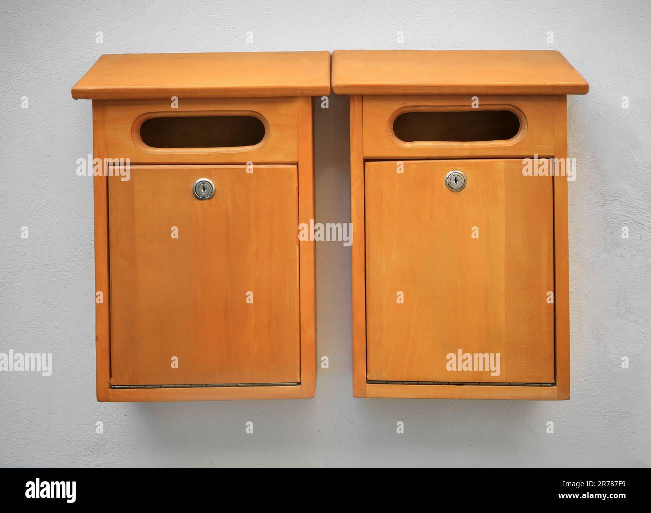 Orange wooden letter boxes on white wall Stock Photo - Alamy