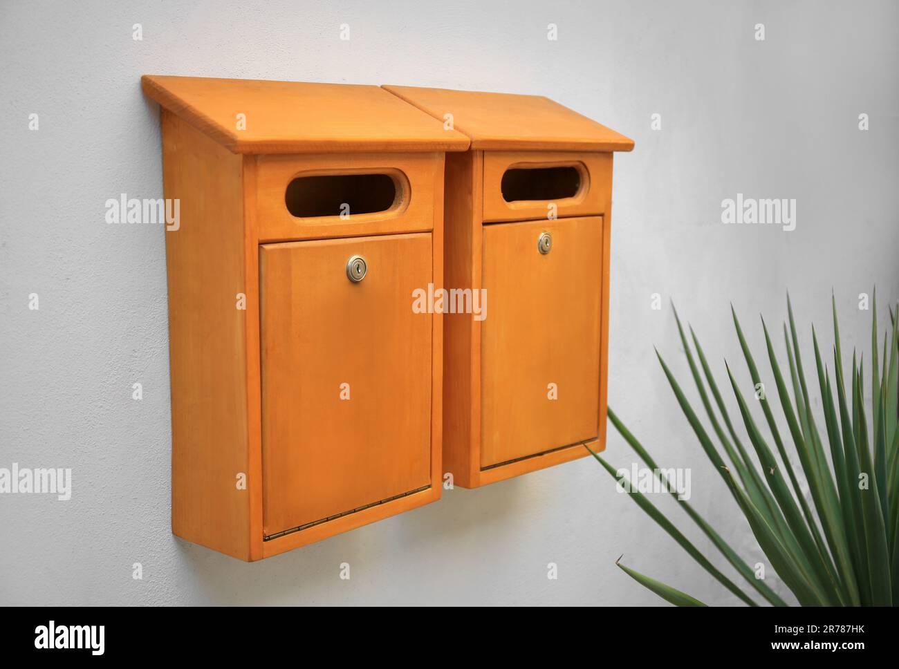 Orange wooden letter boxes on white wall Stock Photo - Alamy