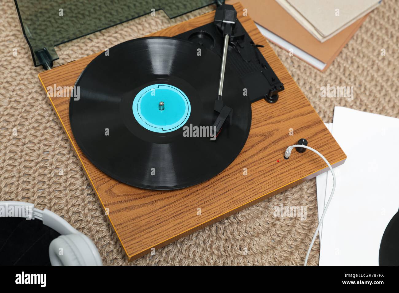 Stylish turntable with vinyl disc and headphones on carpet at home ...