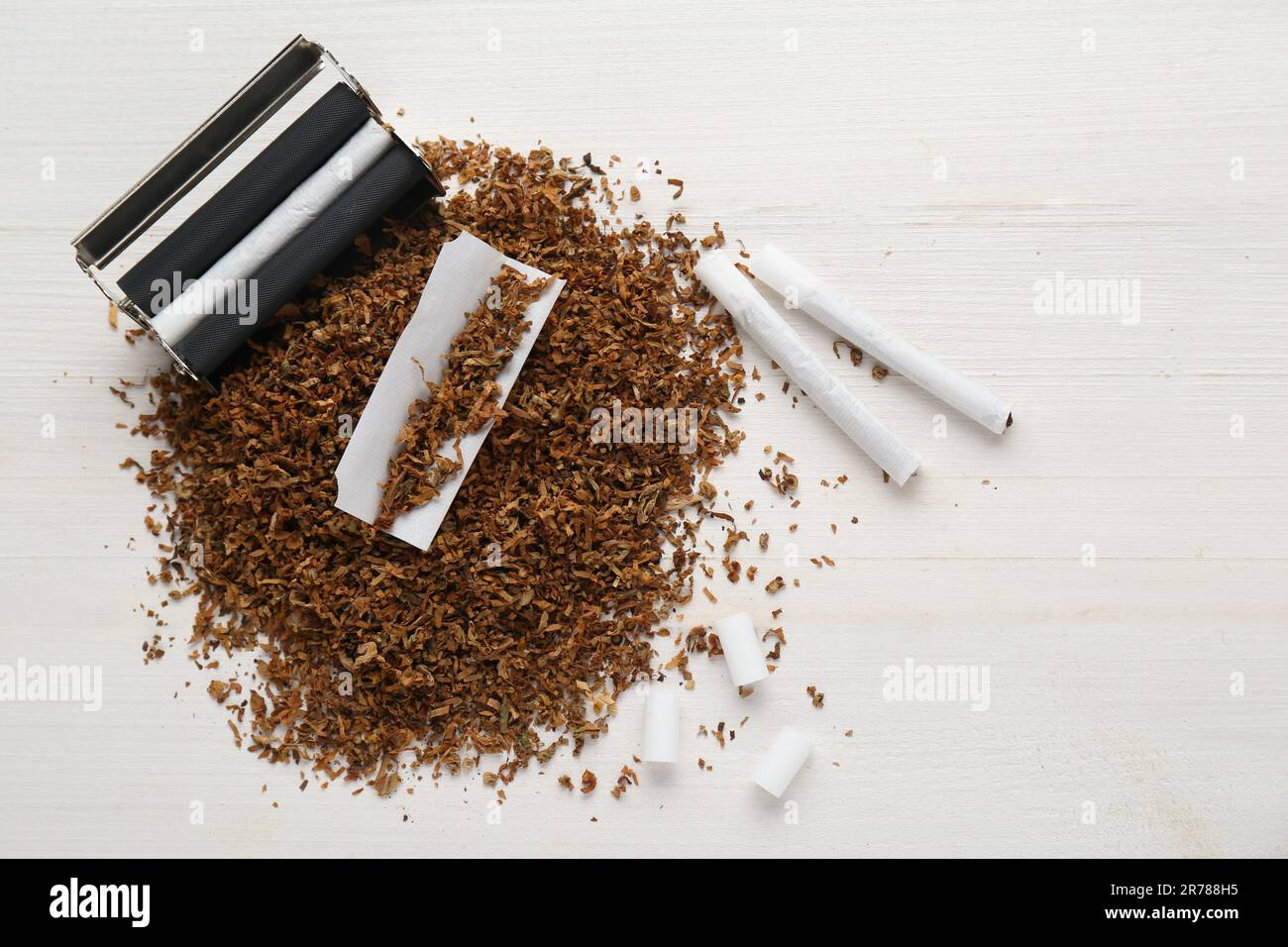 Flat lay composition with roller and tobacco on white wooden table ...