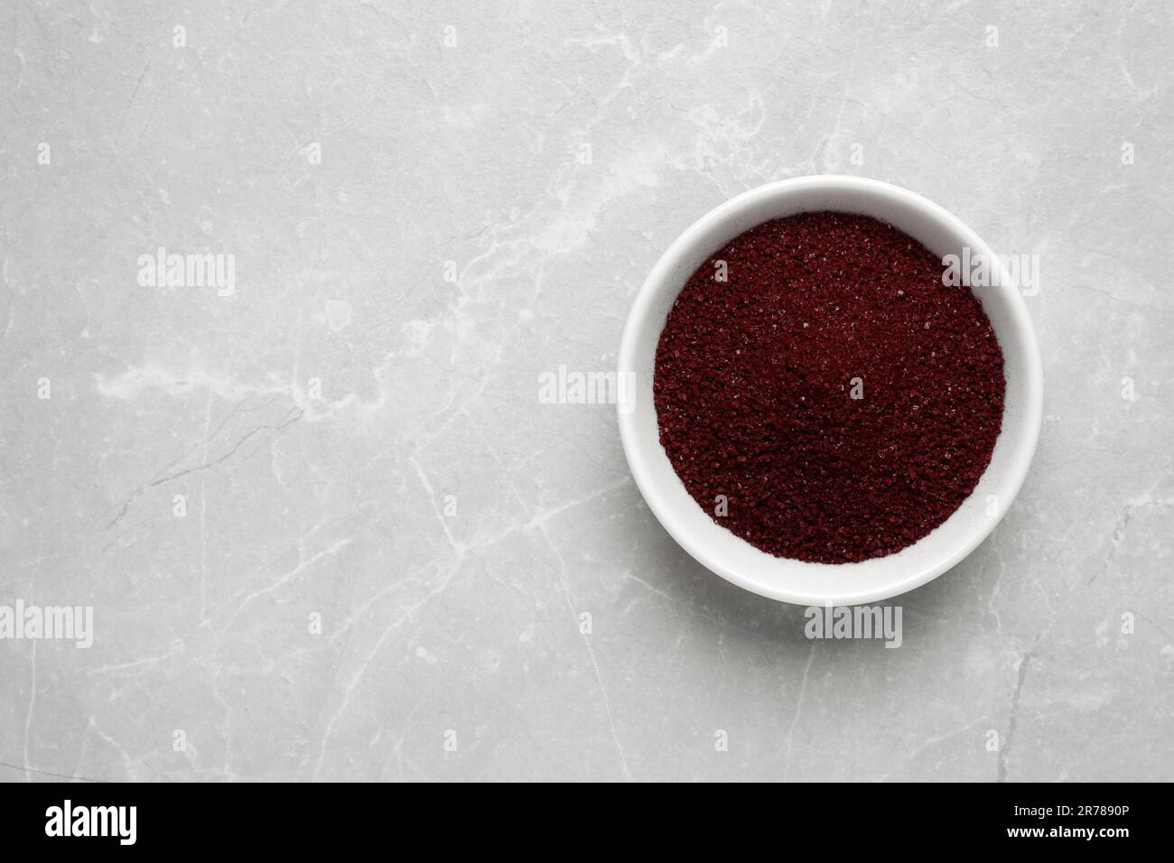 Bowl with dark red food coloring on light grey marble table, top view ...