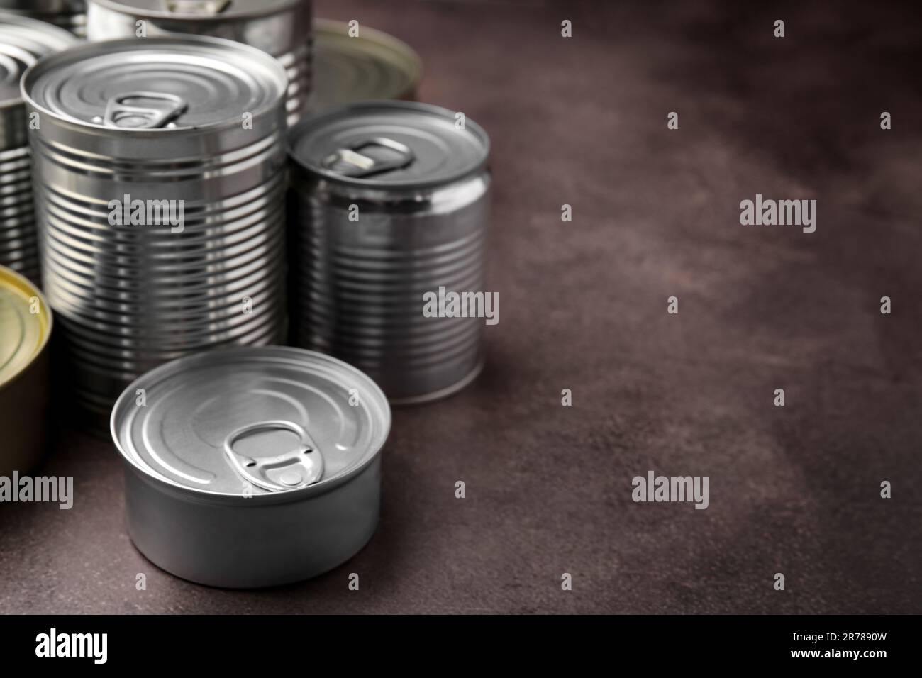 Many closed tin cans on brown table. Space for text Stock Photo - Alamy
