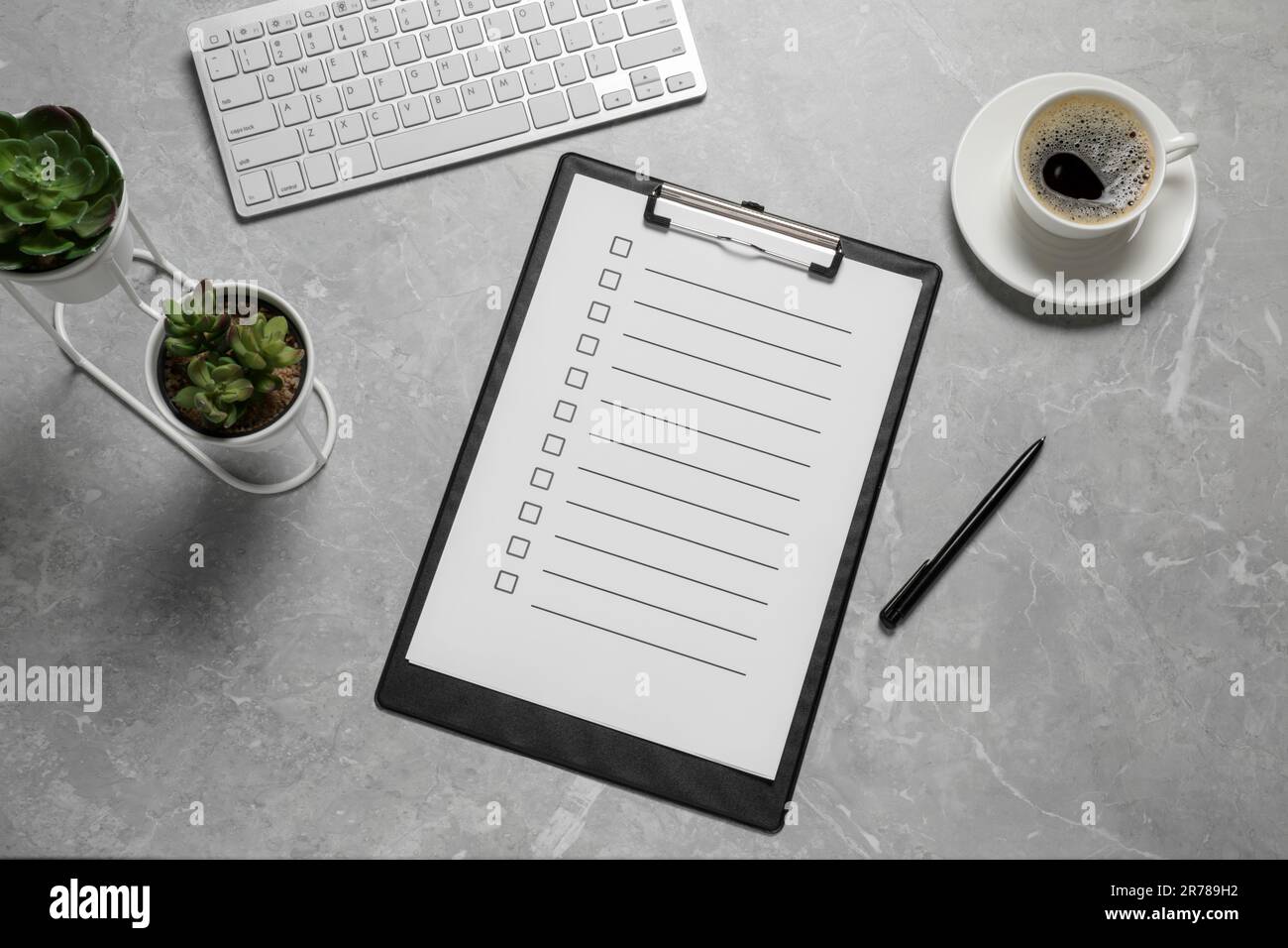 Clipboard with checkboxes, cup of coffee, plants and computer keyboard ...