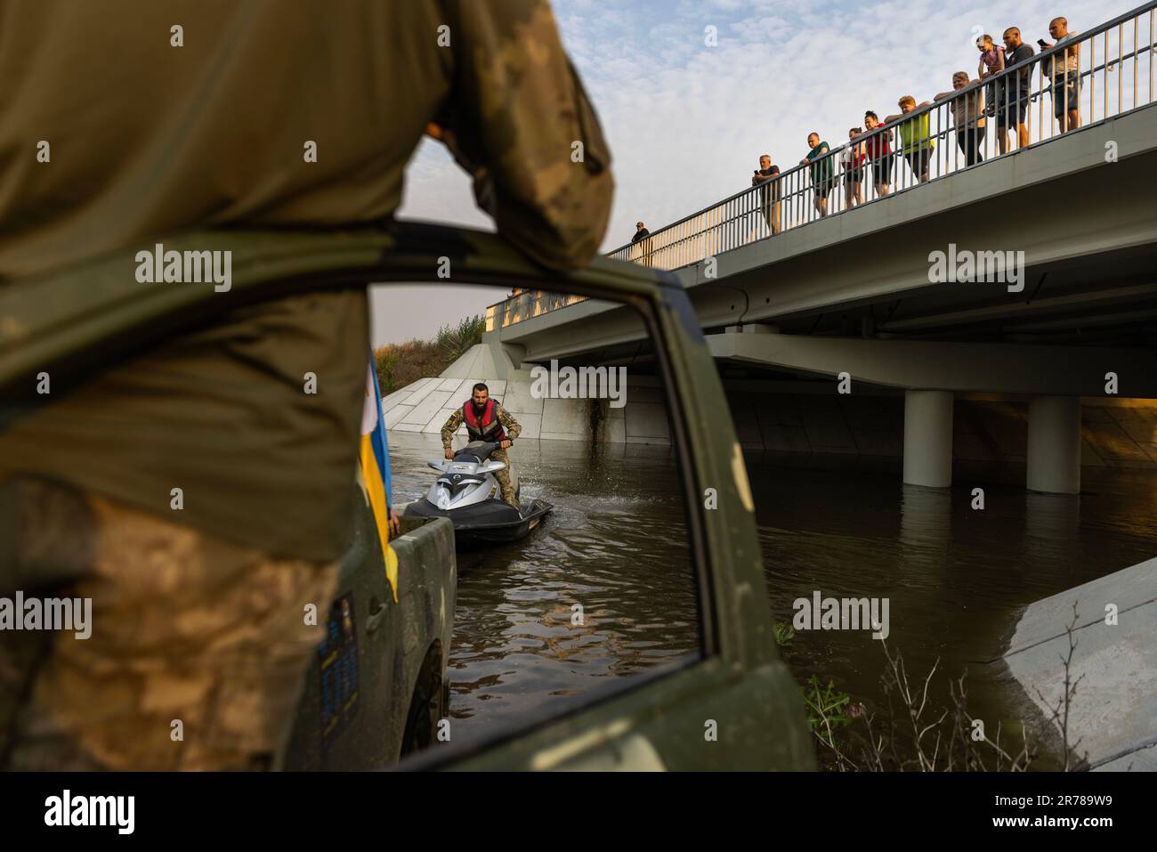 Kherson, Ukraine. 7th June, 2023. People watch as a Ukrainian soldier ...