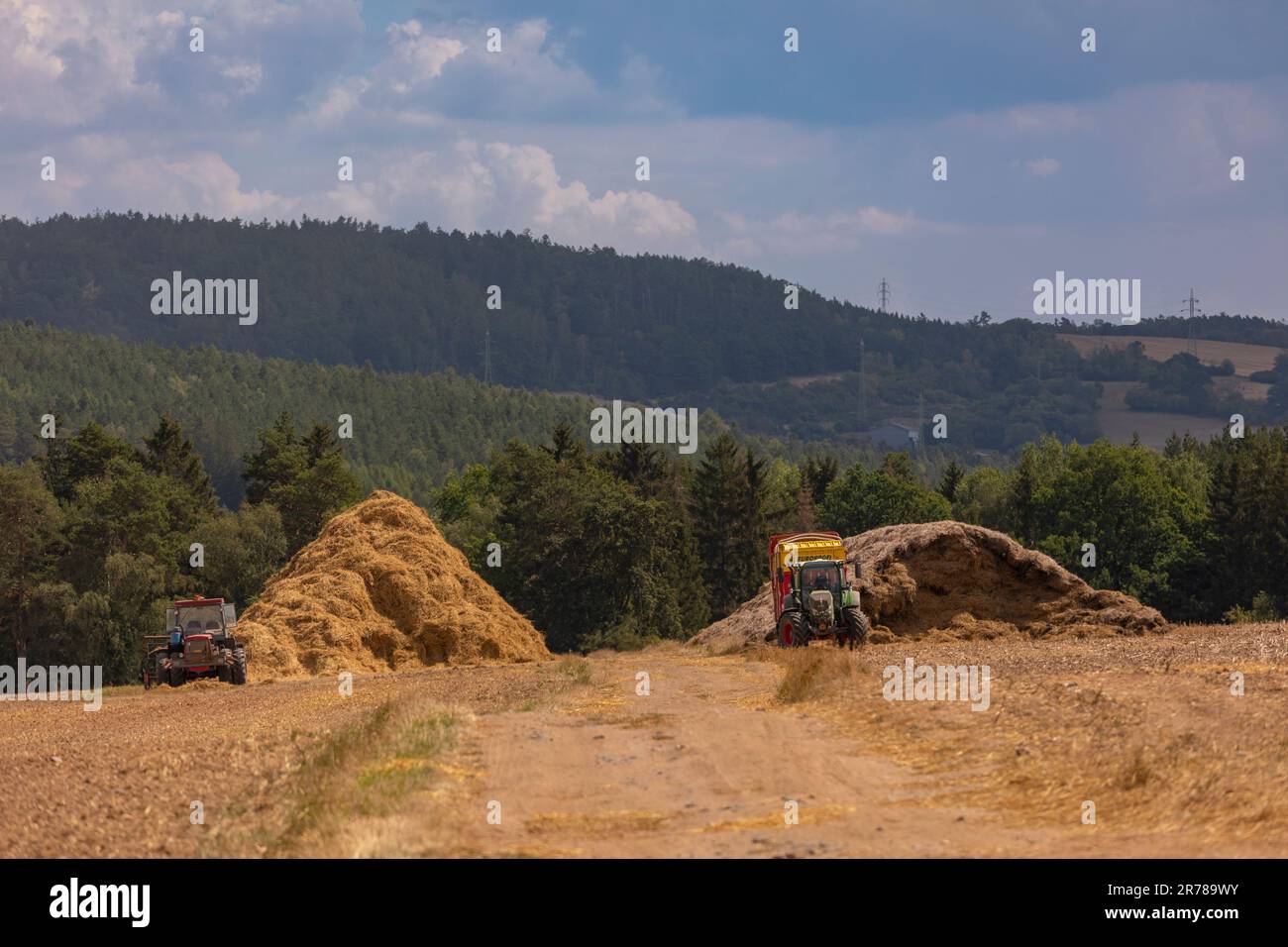 CZECH REPUBLIC, EUROPE - Farm tractors and piles of hay, rural farm ...