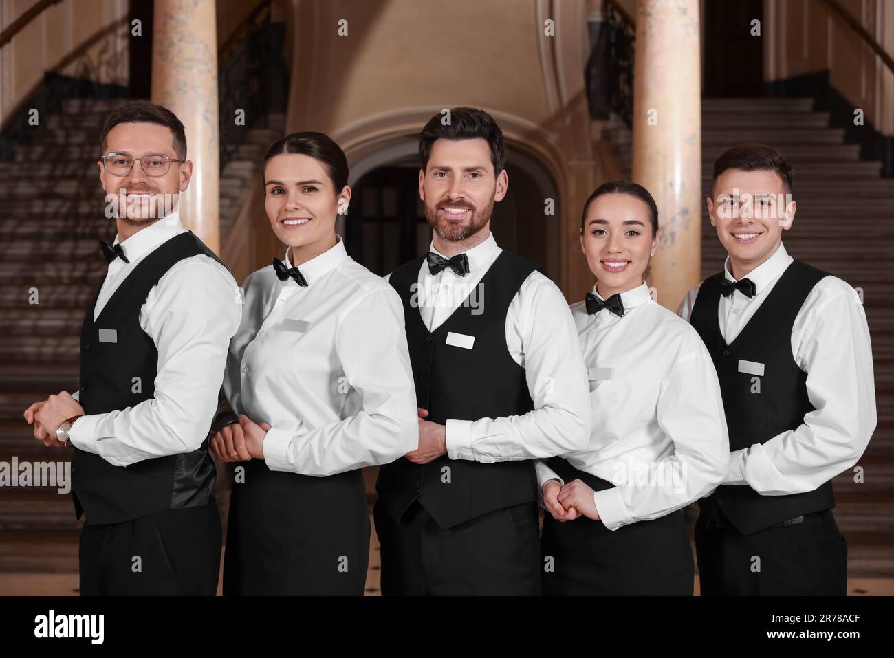 Group of trainees wearing formal clothes in hotel. Professional butler ...