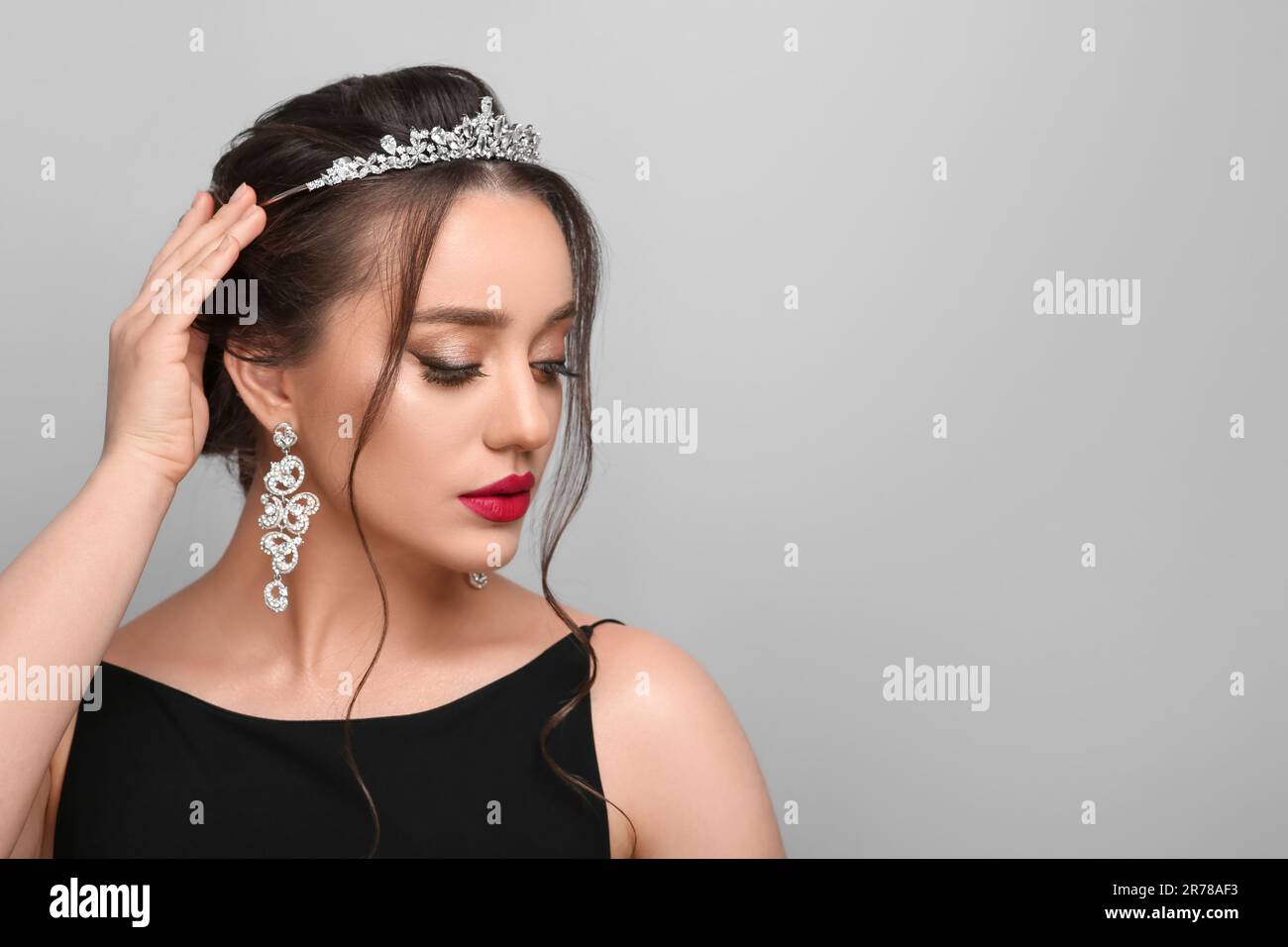 Beautiful young woman wearing luxurious tiara on light grey background, space for text Stock ...