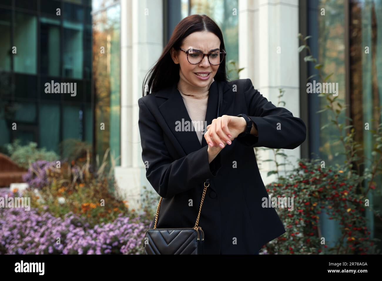 Emotional woman checking time on watch outdoors. Being late concept ...