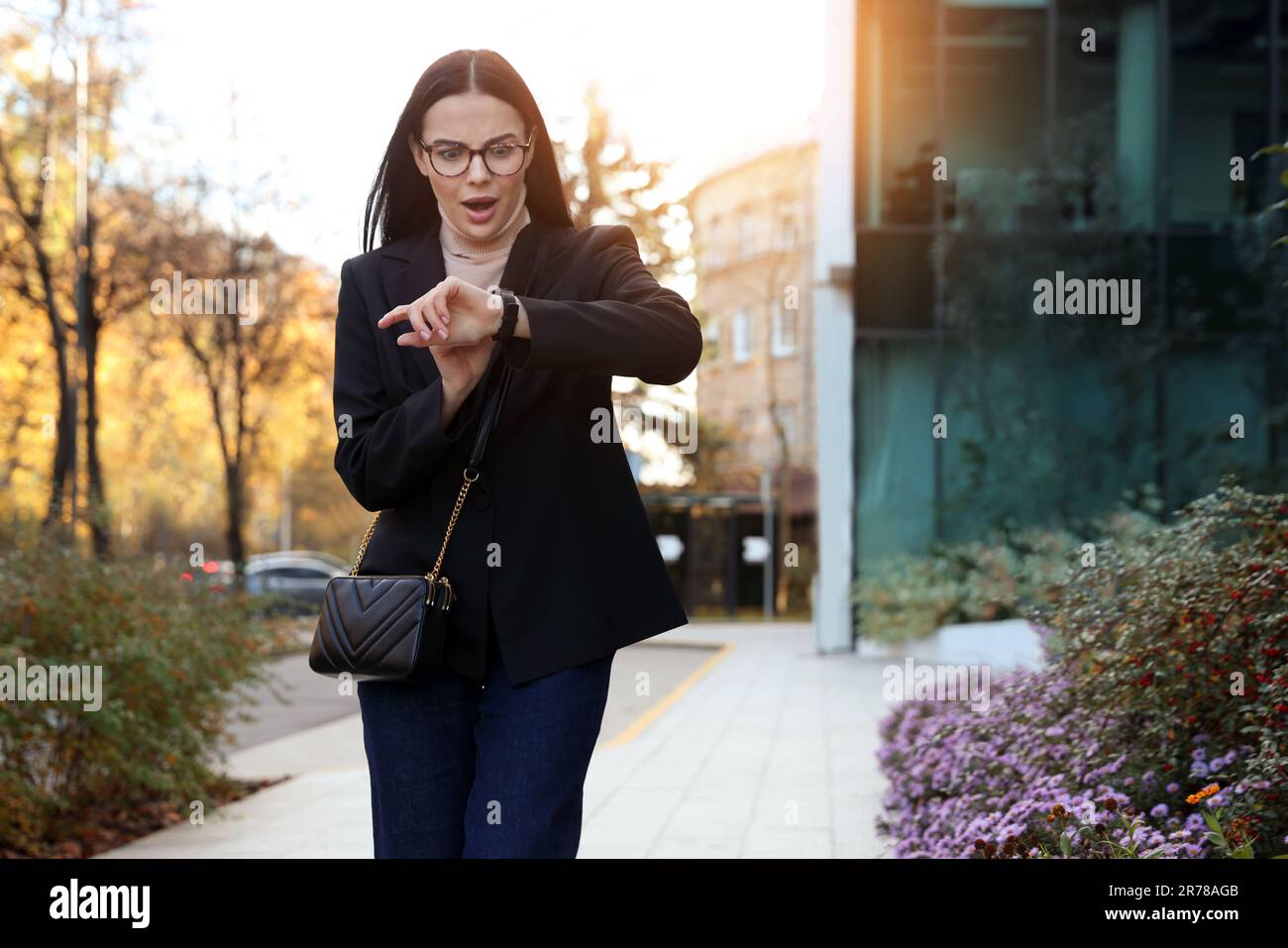 Emotional woman checking time on watch outdoors. Being late concept ...