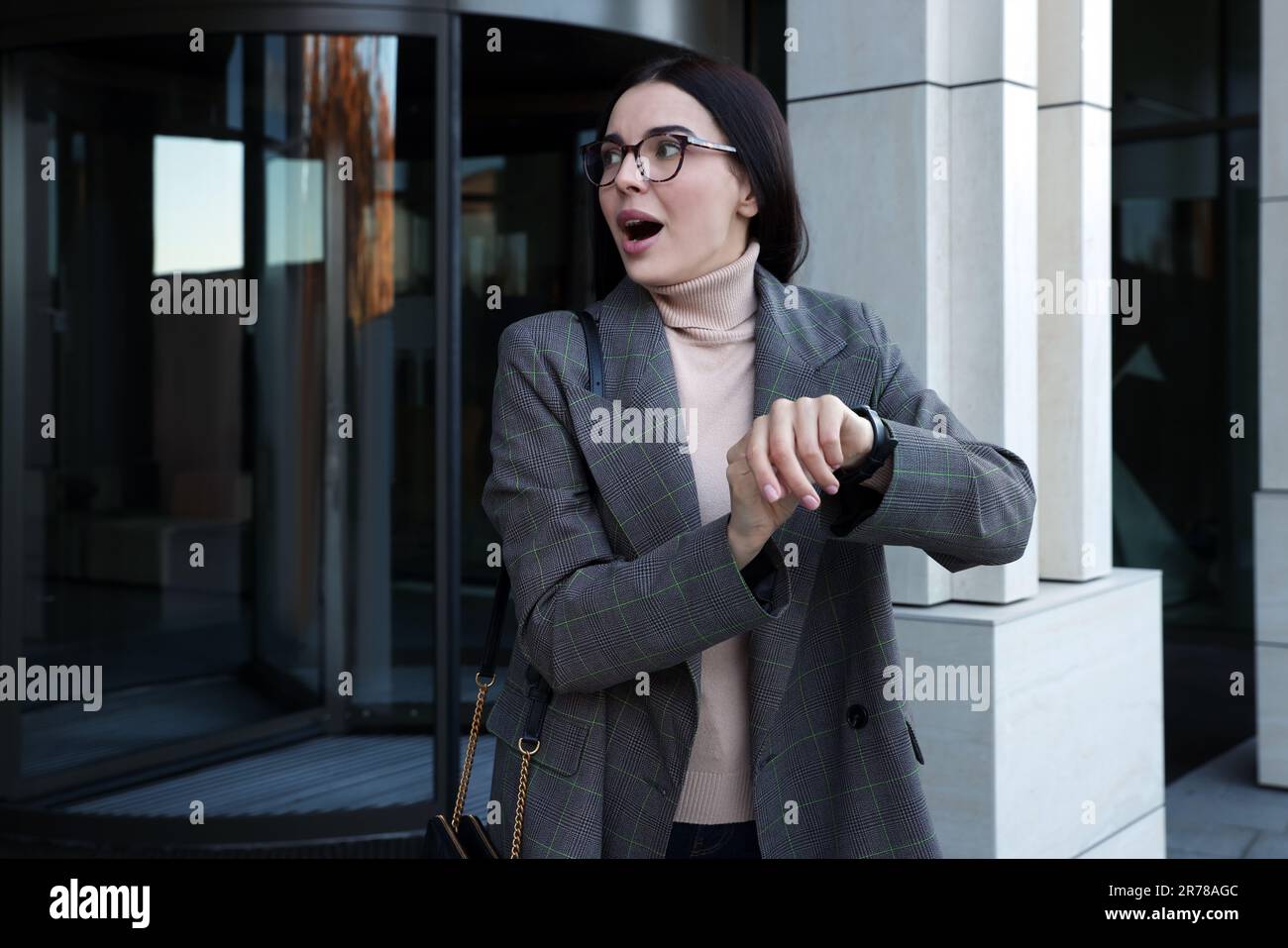 Emotional woman checking time on watch outdoors. Being late concept ...