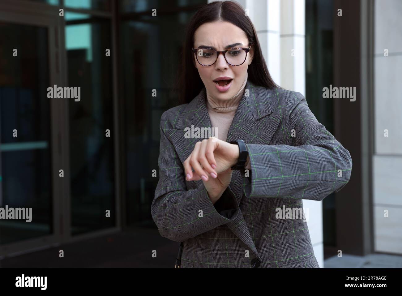 Emotional woman checking time on watch outdoors. Being late concept ...