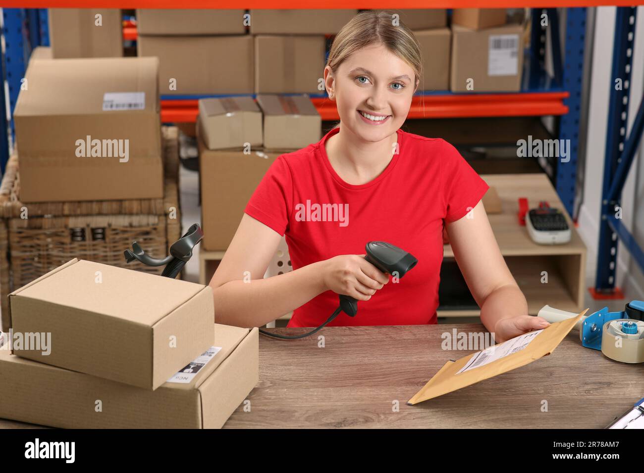 Post office worker with scanner reading parcel barcode at counter ...