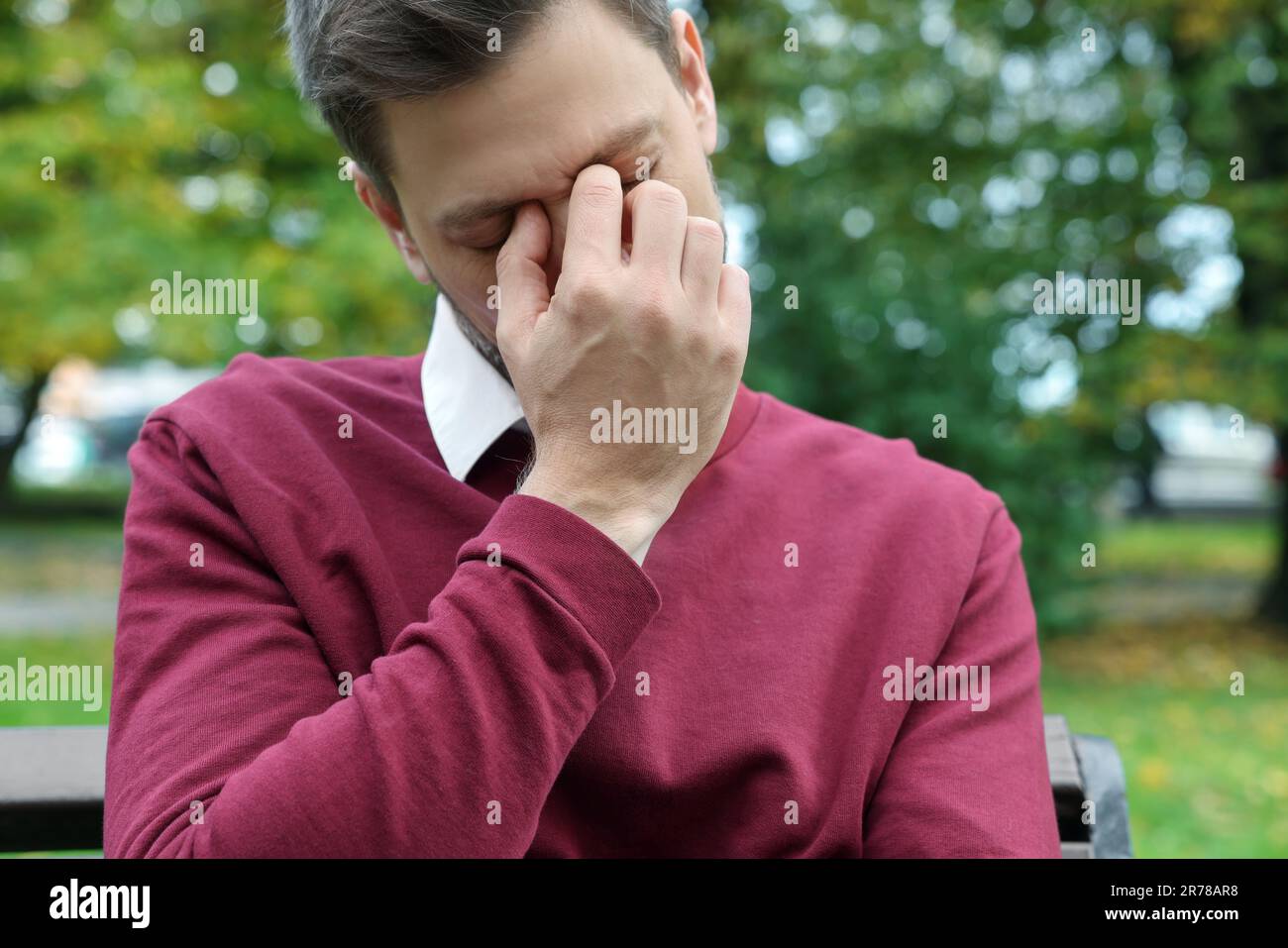 Sleepy tired man on bench in beautiful green park, closeup Stock Photo ...