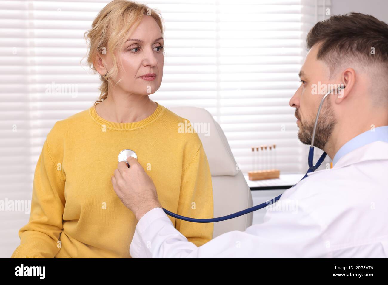 Doctor listening to patient's lungs with stethoscope in clinic Stock ...