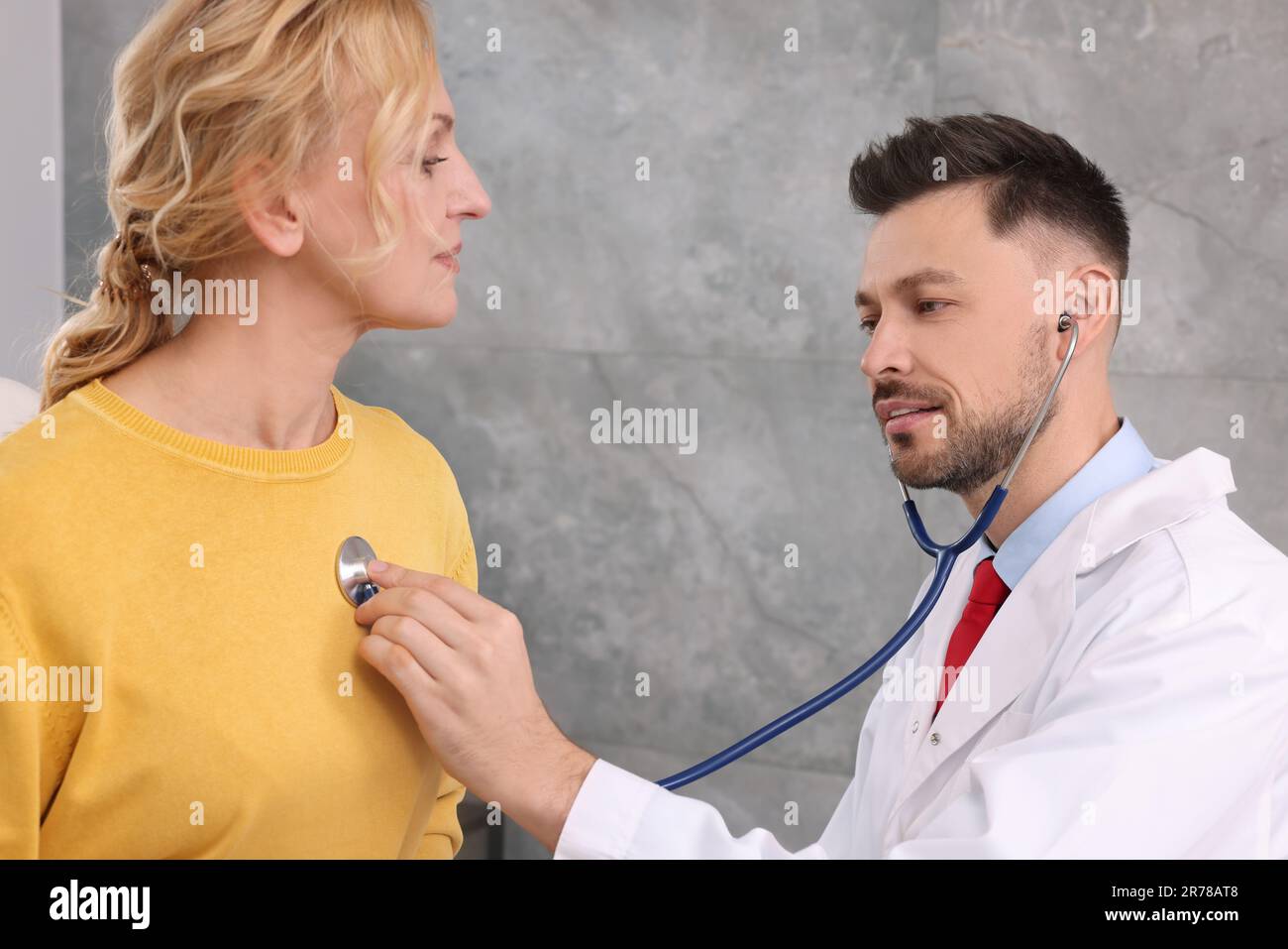 Doctor listening to patient's lungs with stethoscope in clinic Stock ...