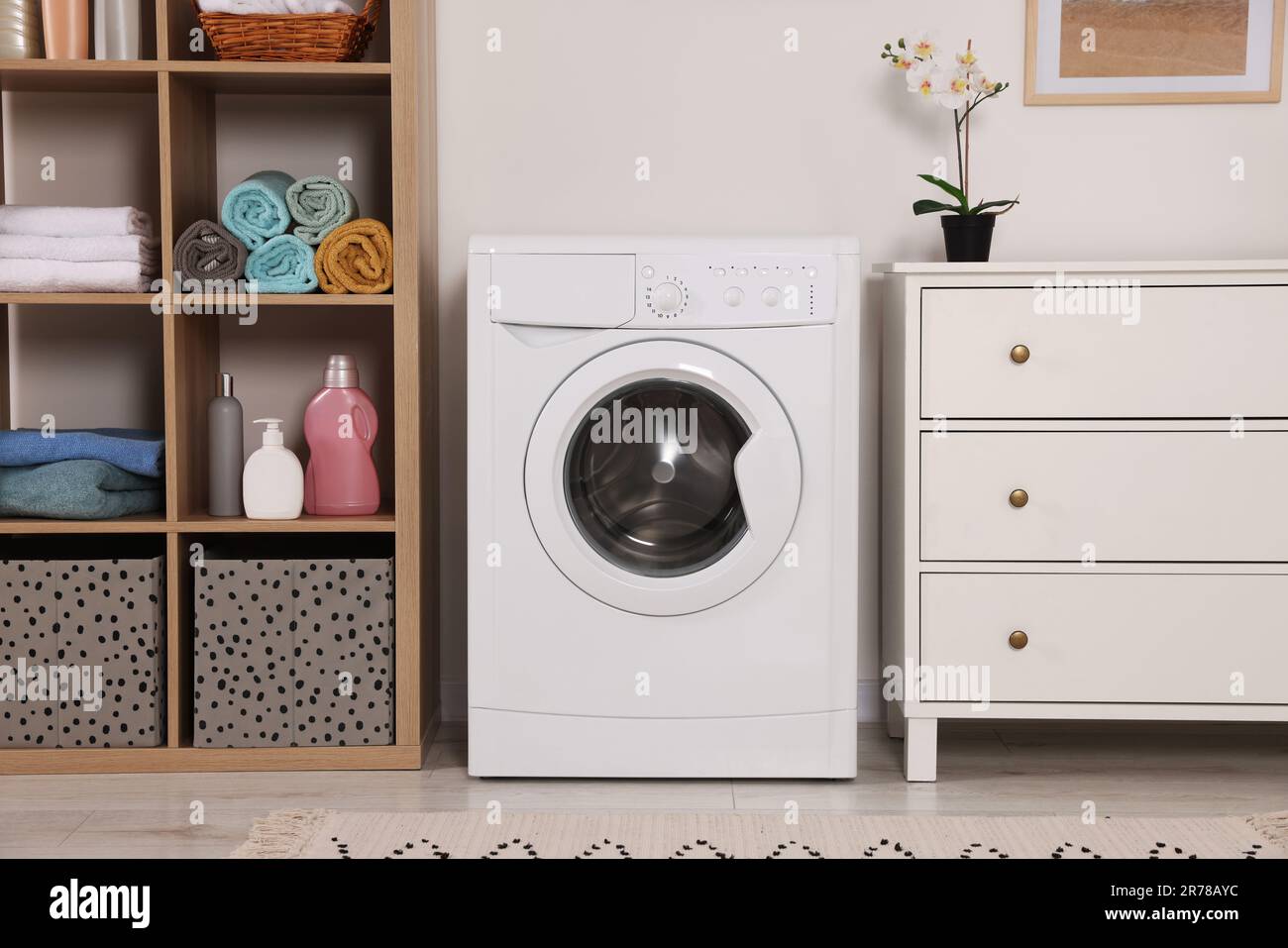 Stylish laundry room with washing machine and chest of drawers ...