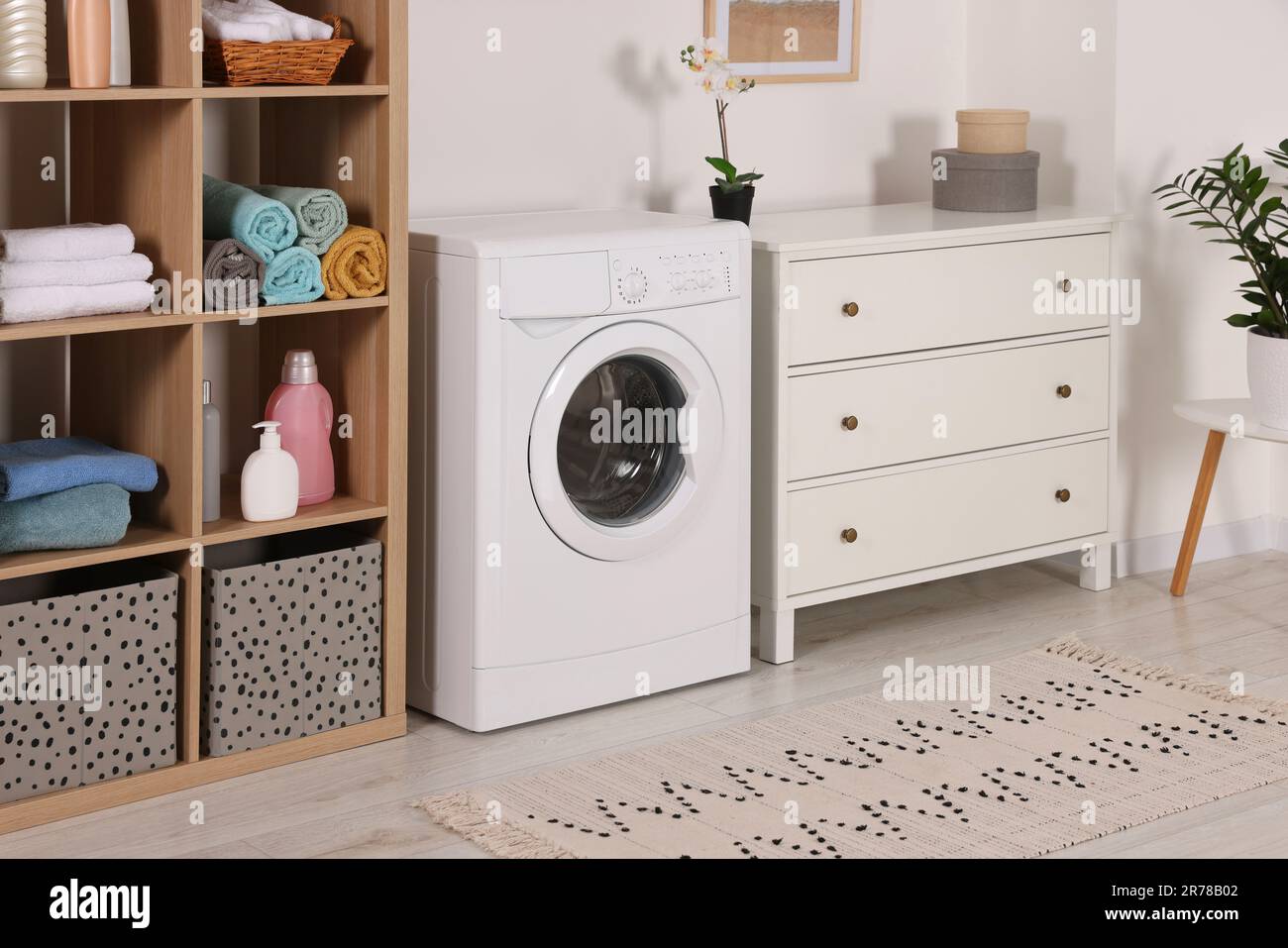 Stylish laundry room with washing machine and chest of drawers ...