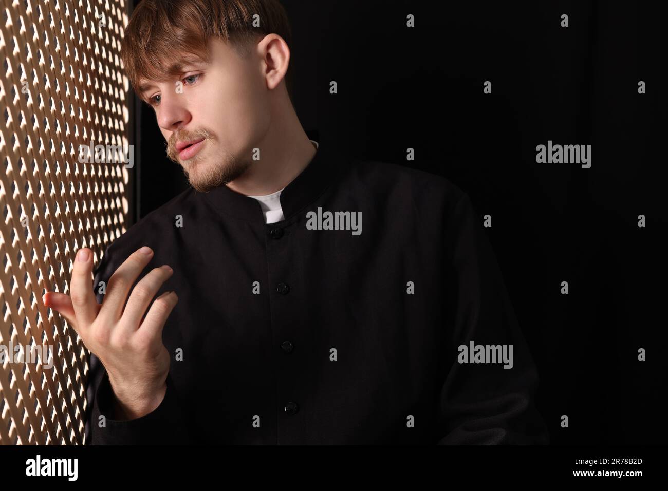 Catholic priest talking to parishioner in confessional booth Stock ...