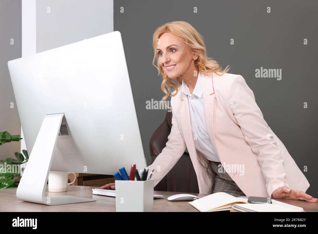 Happy lady boss working on computer in office. Successful businesswoman ...