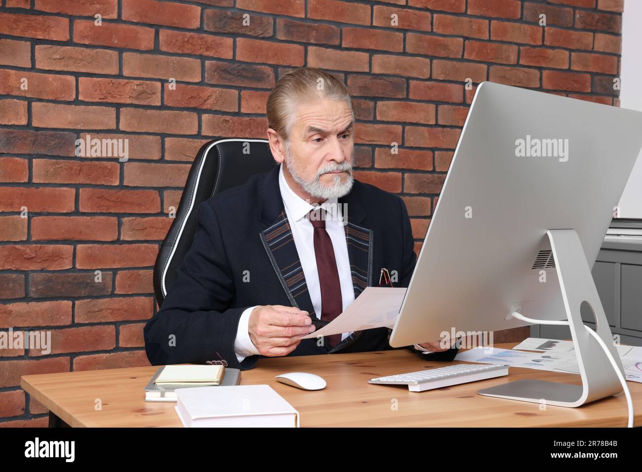 Serious senior boss working in his office Stock Photo - Alamy