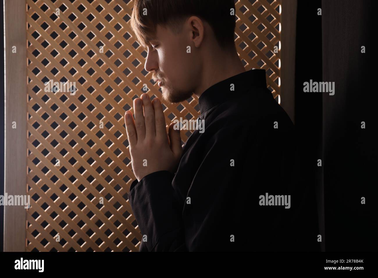 Catholic priest praying near wooden window in confessional booth Stock ...