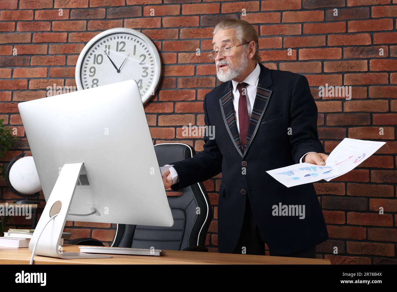 Senior boss holding paper sheets in his modern office Stock Photo - Alamy