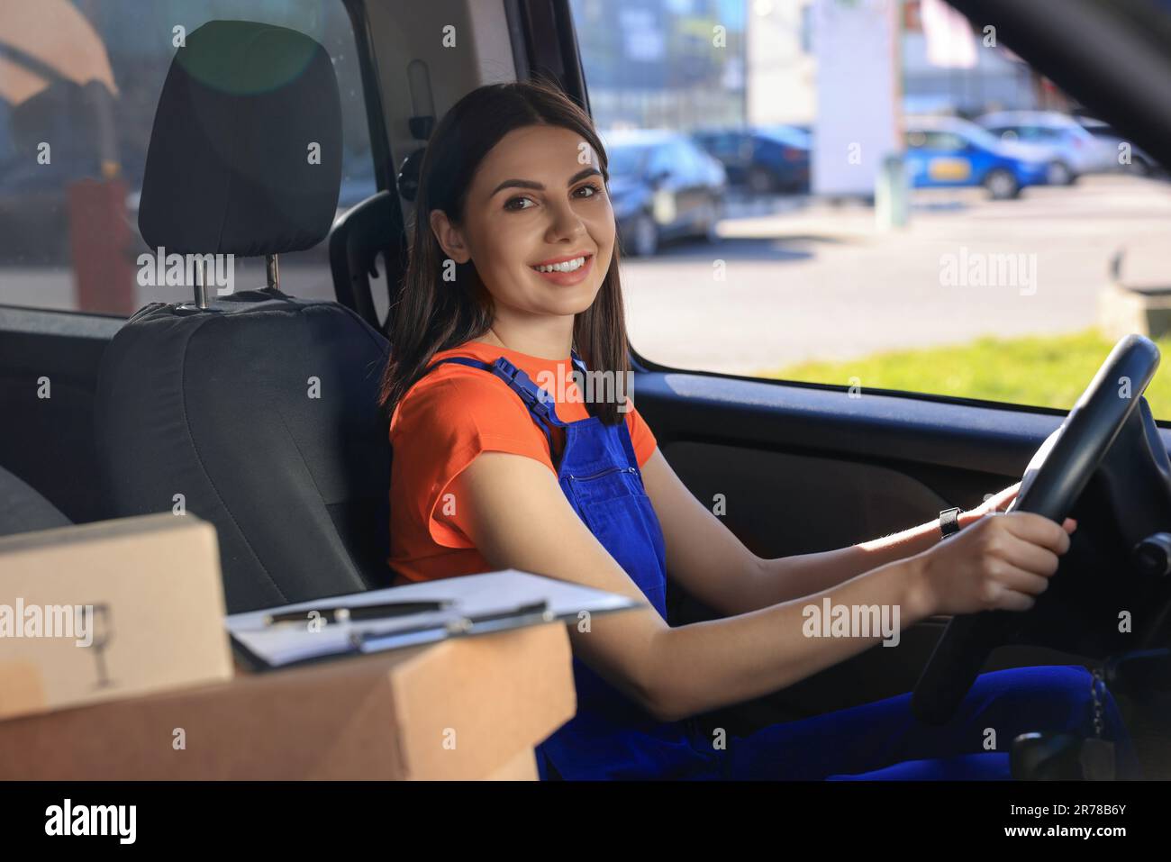 Courier with clipboard and parcels in car. Delivery service Stock Photo ...