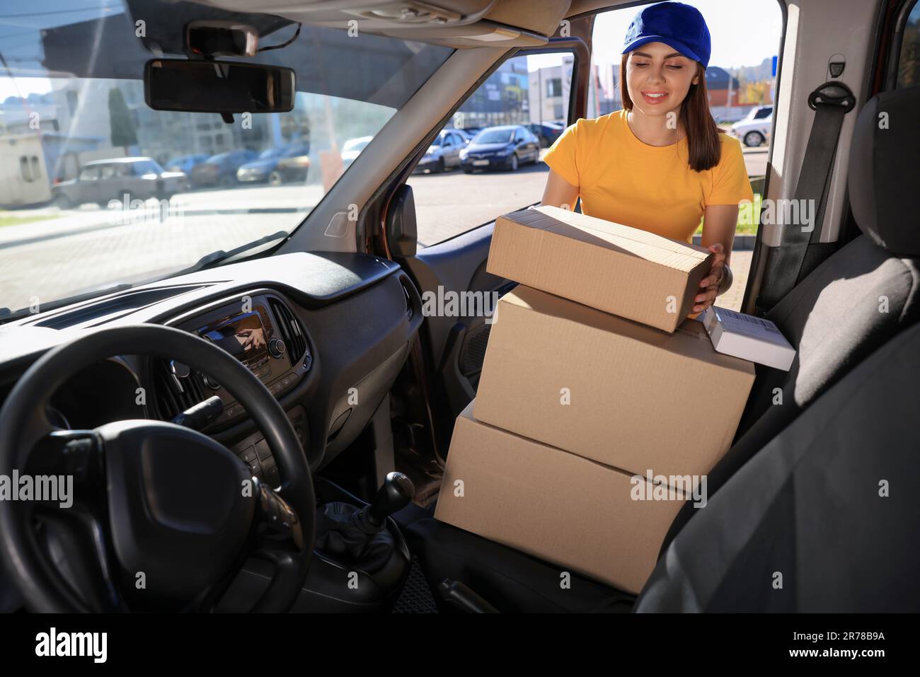 Courier taking parcel from car. Delivery service Stock Photo - Alamy