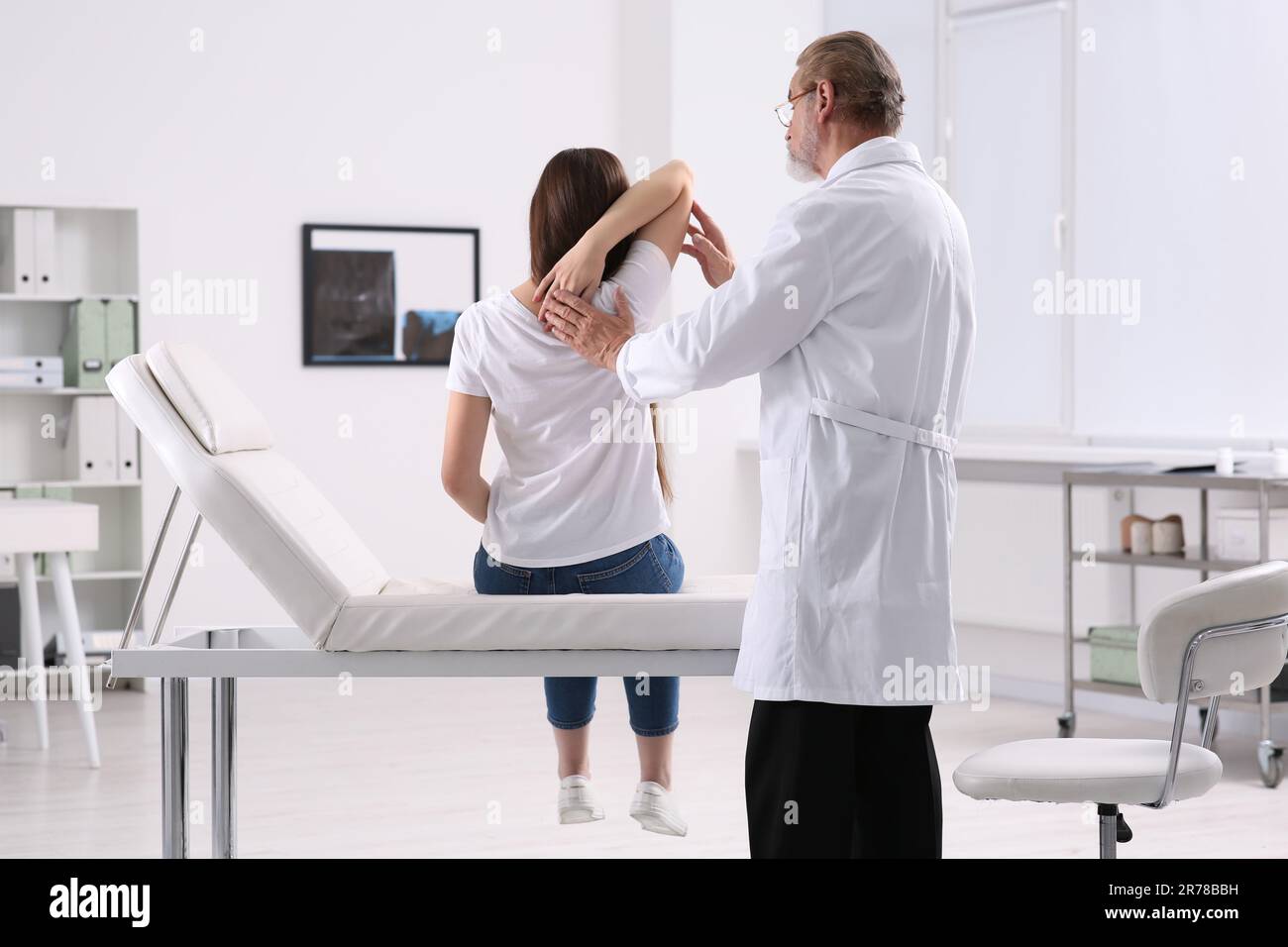 Professional Orthopedist Examining Patients Shoulder In Clinic Stock