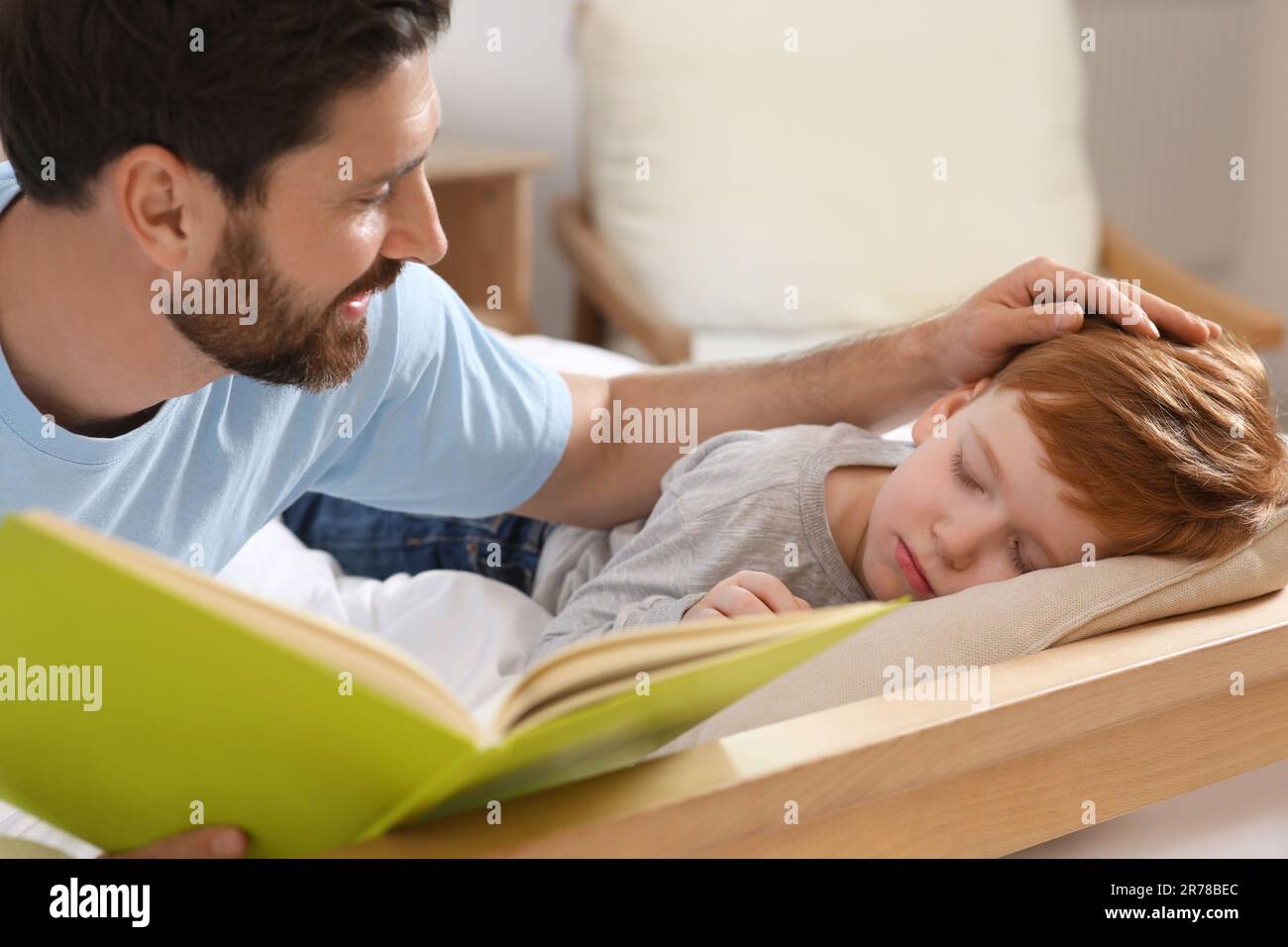 Father reading book with his child on bed at home, closeup Stock Photo ...