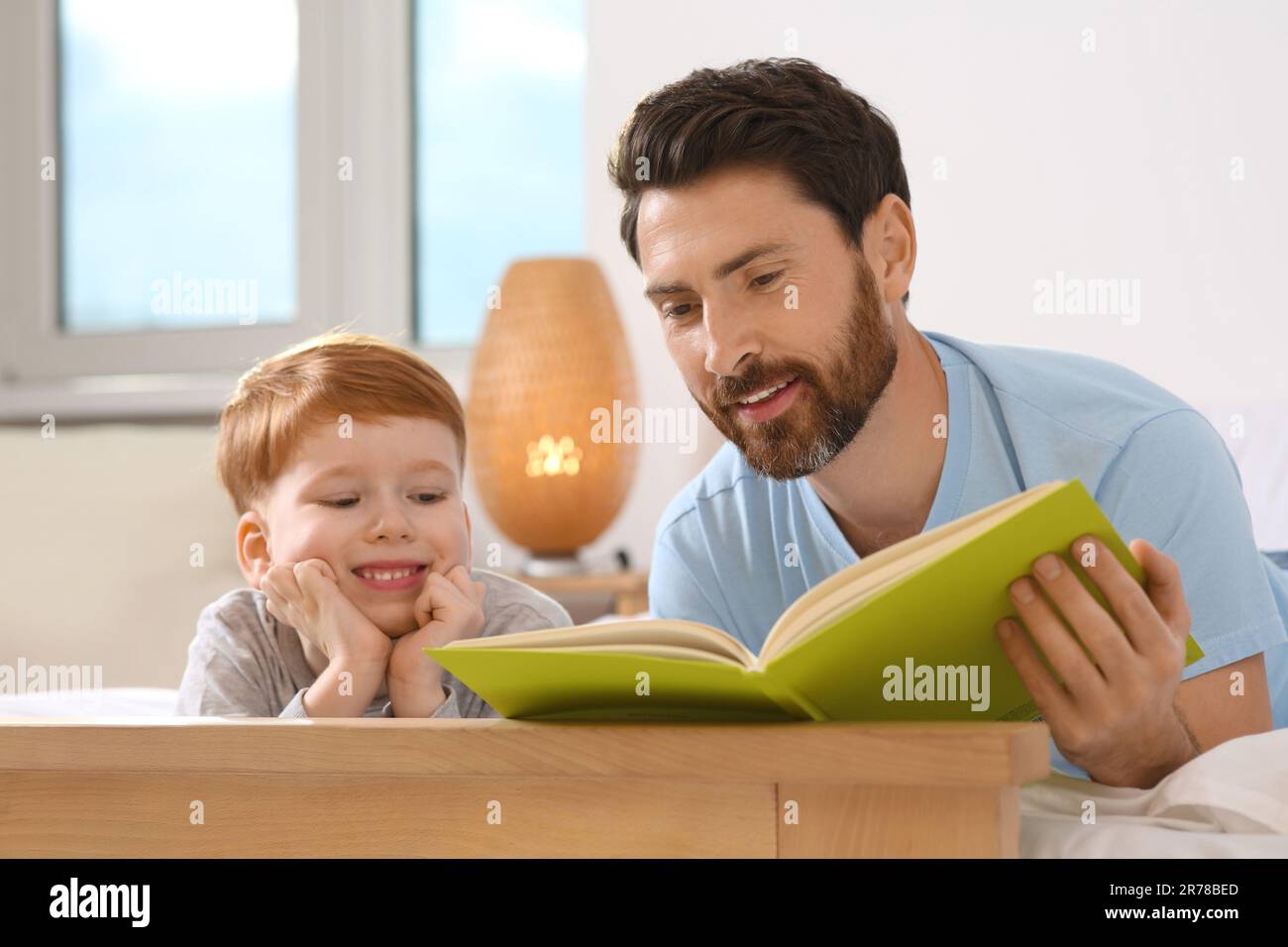 Father reading book with his child on bed at home Stock Photo - Alamy