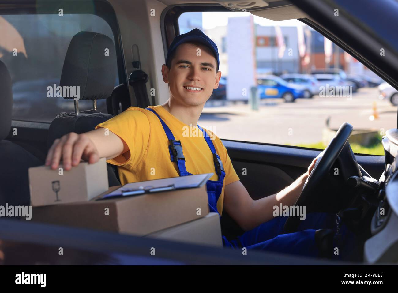 Courier with clipboard and parcels in car. Delivery service Stock Photo ...