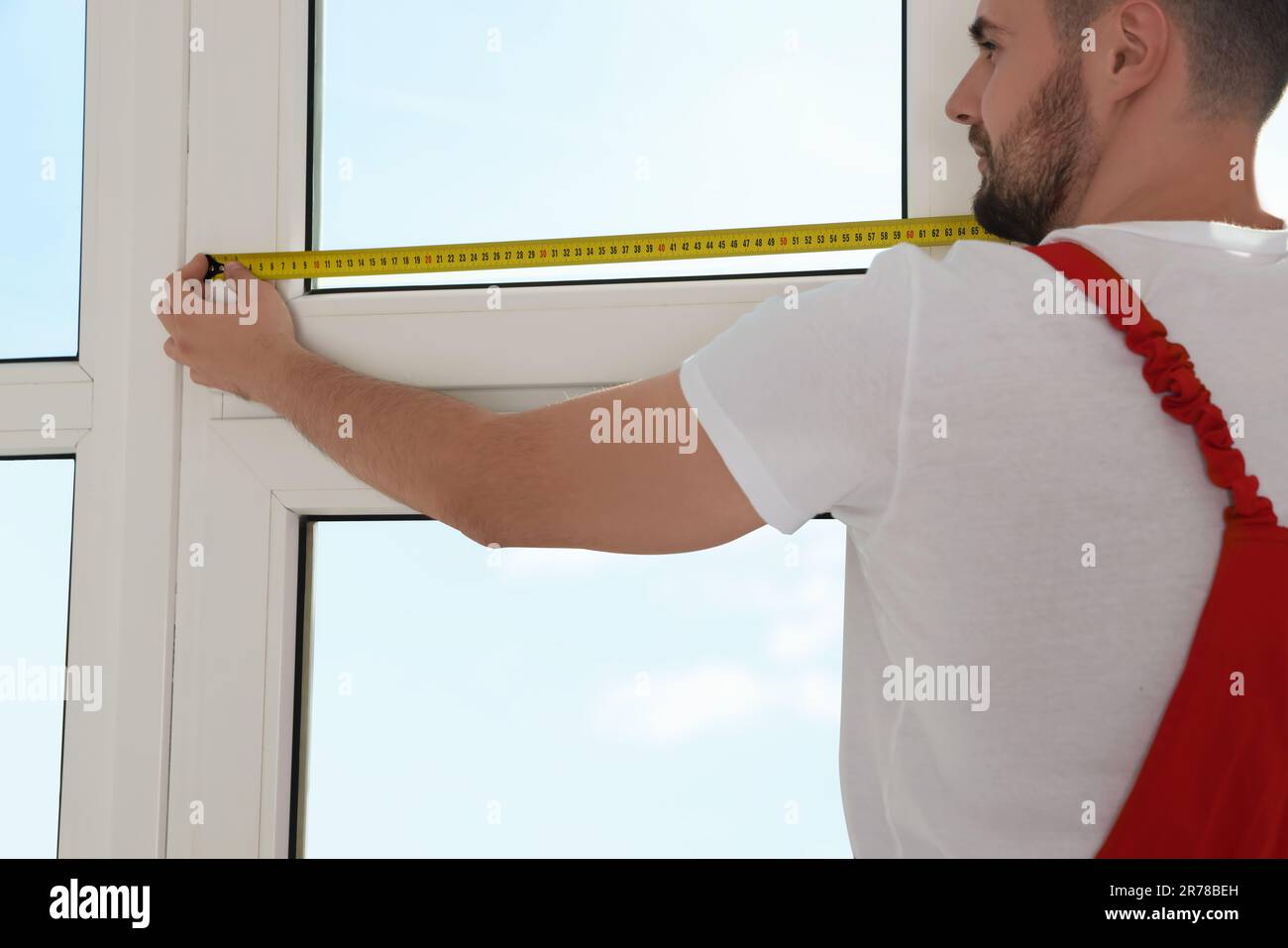 Worker measuring window with tape indoors, closeup. Roller blinds ...