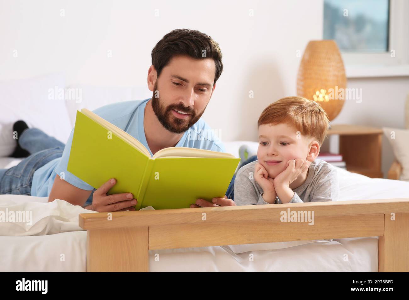 Father reading book with his child on bed at home Stock Photo - Alamy