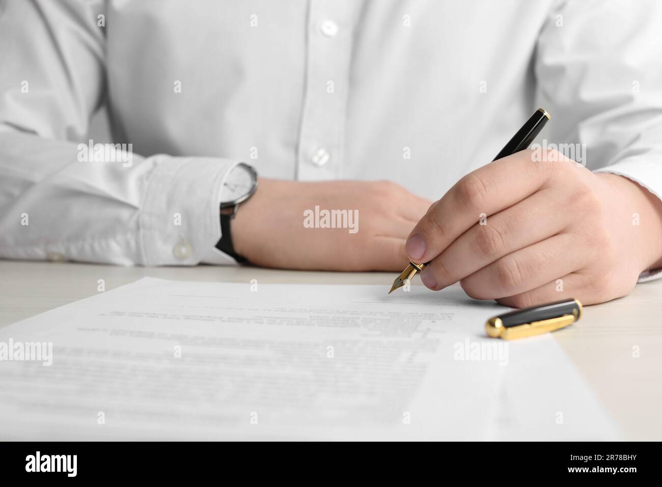 Notary signing document at wooden table, closeup Stock Photo - Alamy