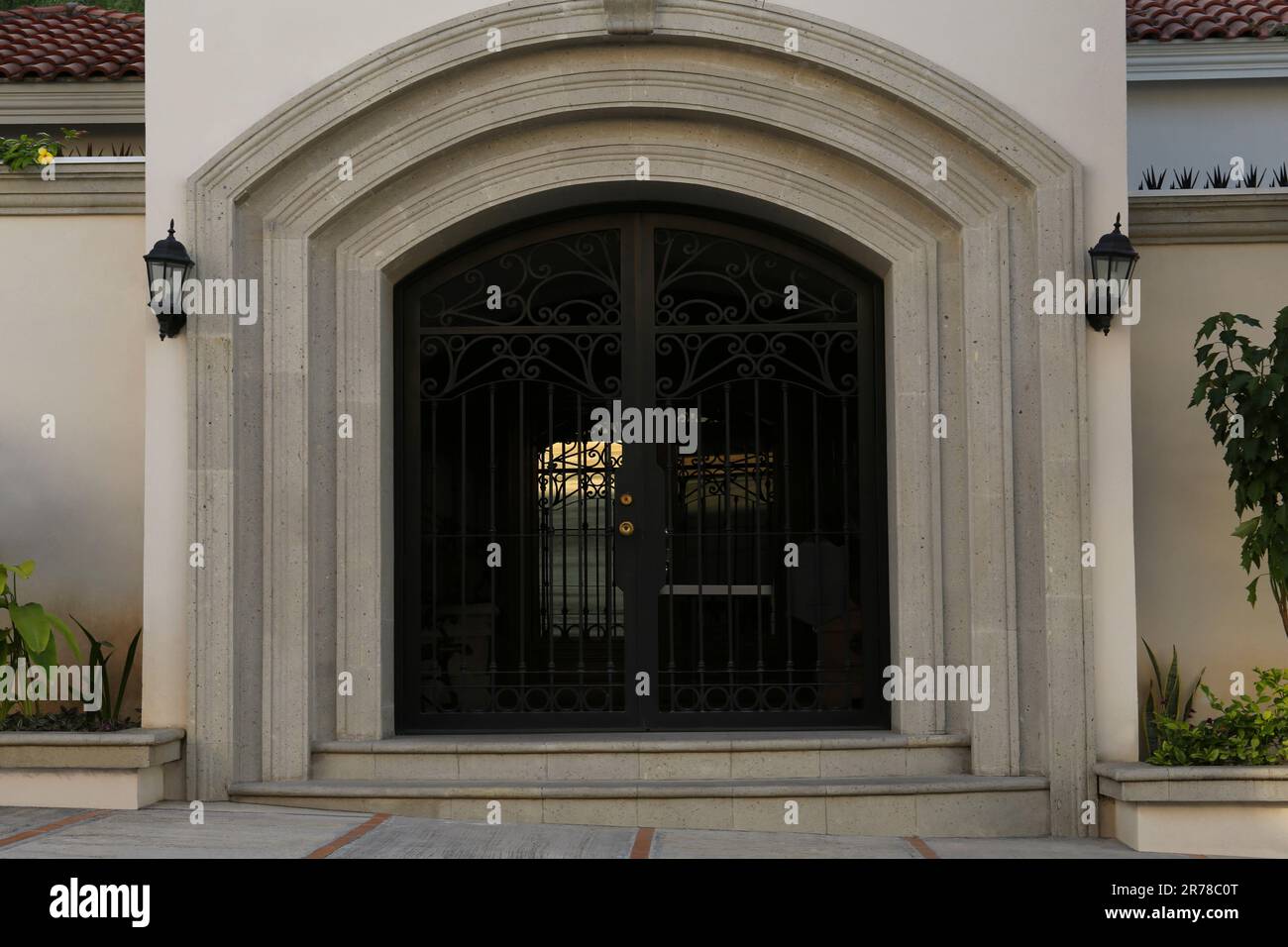 Entrance of house with beautiful arch and metal gate Stock Photo - Alamy