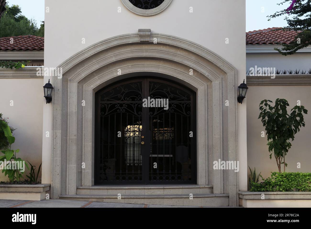 Entrance of house with beautiful arch and metal gate Stock Photo - Alamy