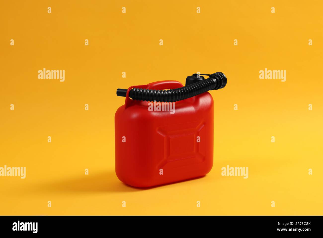 Red plastic canister with tube on orange background Stock Photo - Alamy