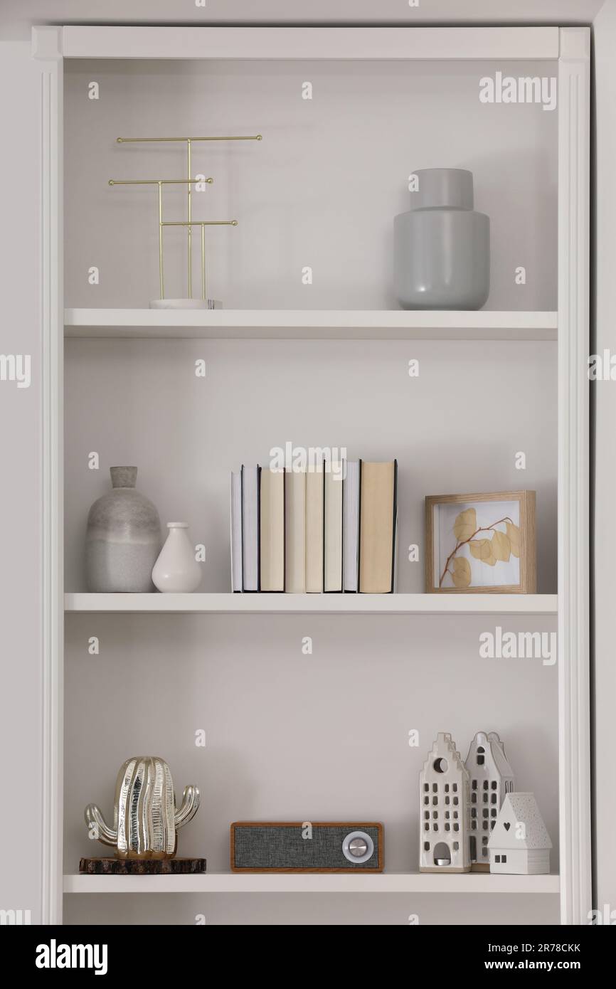 Stylish shelves with different decor elements in room. Interior design ...
