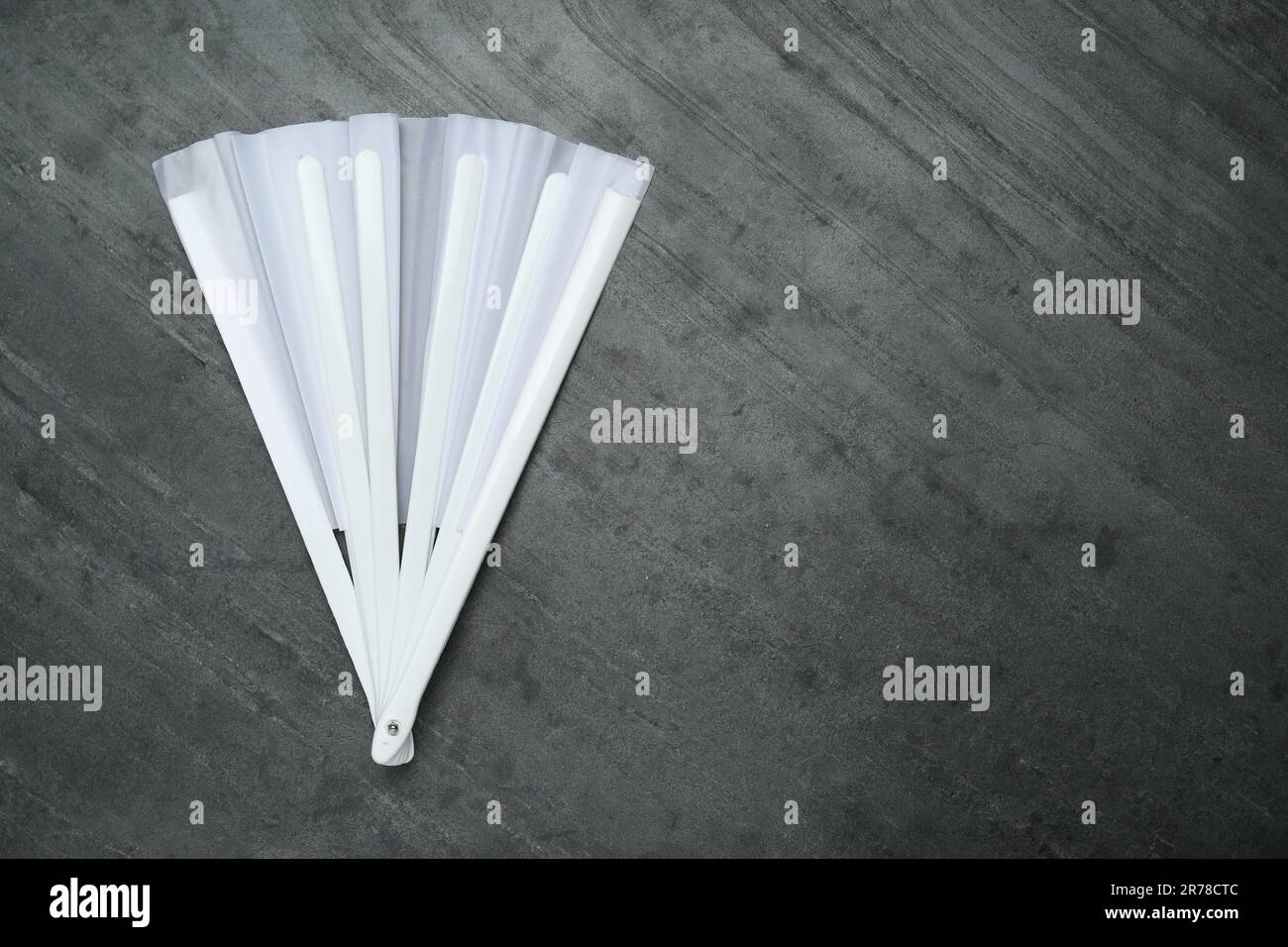 Stylish white hand fan on grey background, top view. Space for text ...