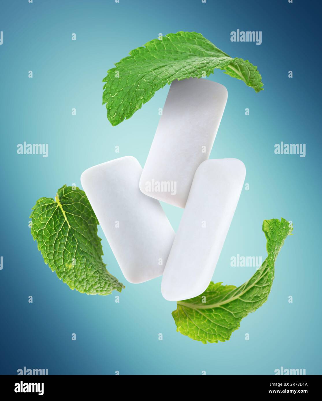 Fresh mint leaves and chewing gum pads flying on light blue background ...