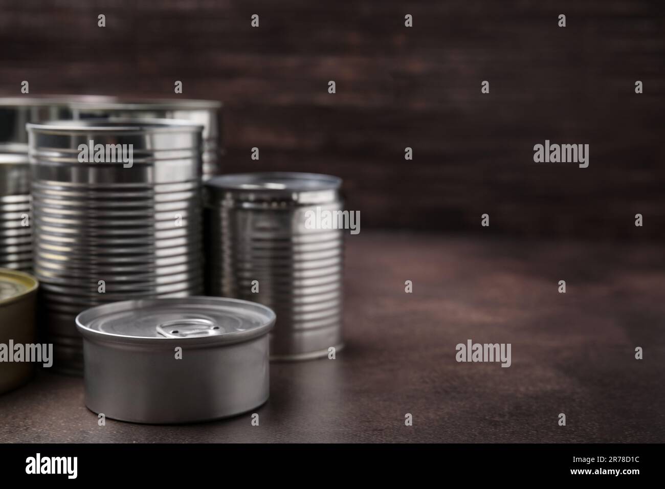 Many closed tin cans on brown table. Space for text Stock Photo - Alamy