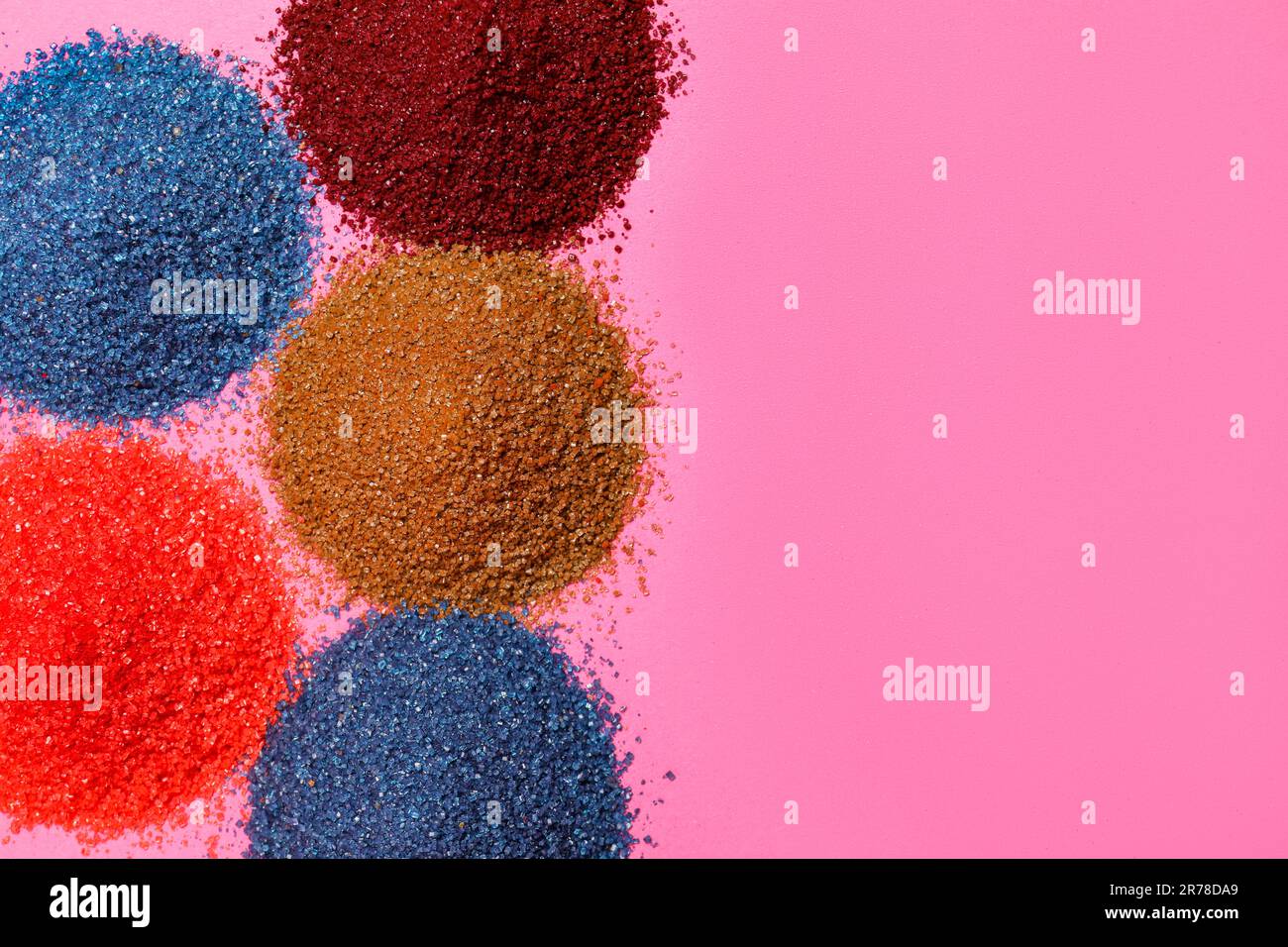 Heaps of different bright food coloring on pink background, flat lay ...