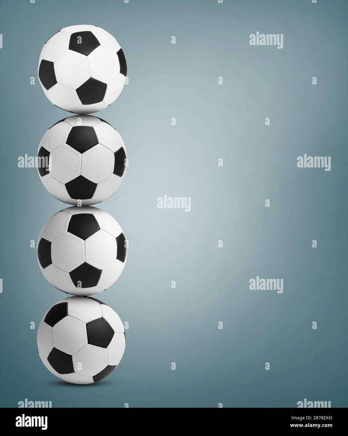 Stack of soccer balls on dusty light blue background. Space for text ...