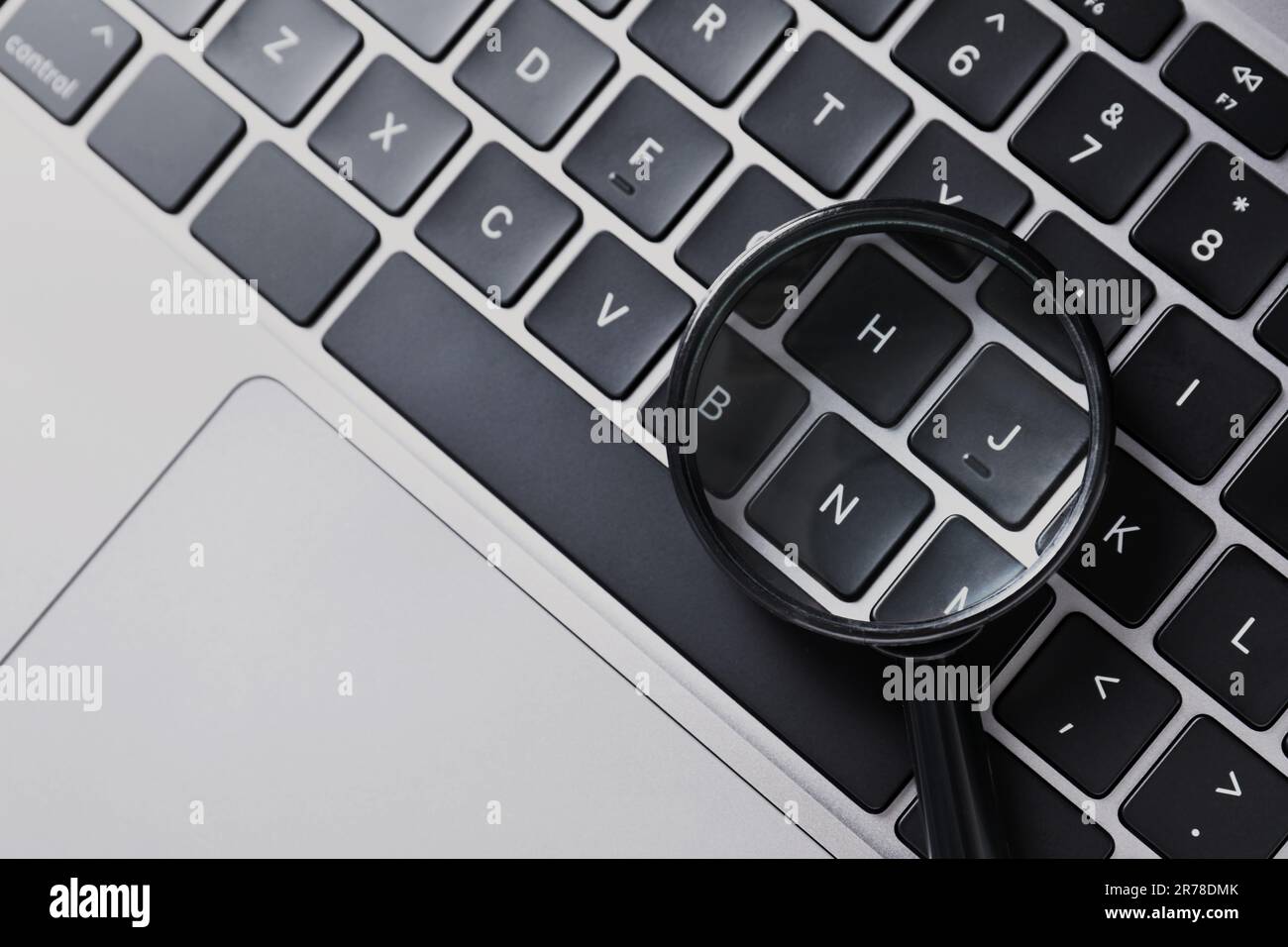 Magnifying glass on keyboard of laptop, top view Stock Photo - Alamy