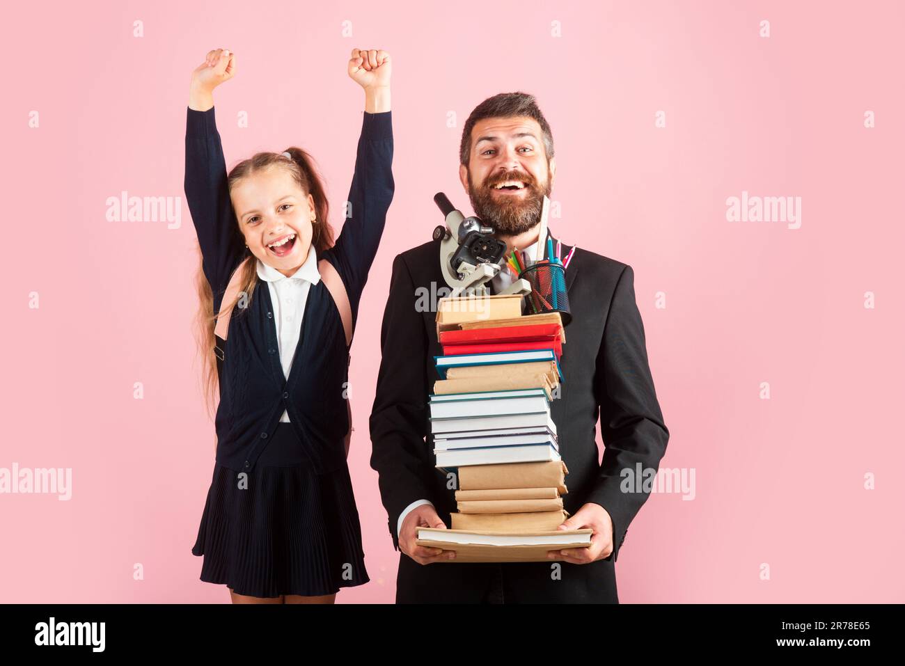 Cheerful smiling little girl in school uniform having fun in classroom ...