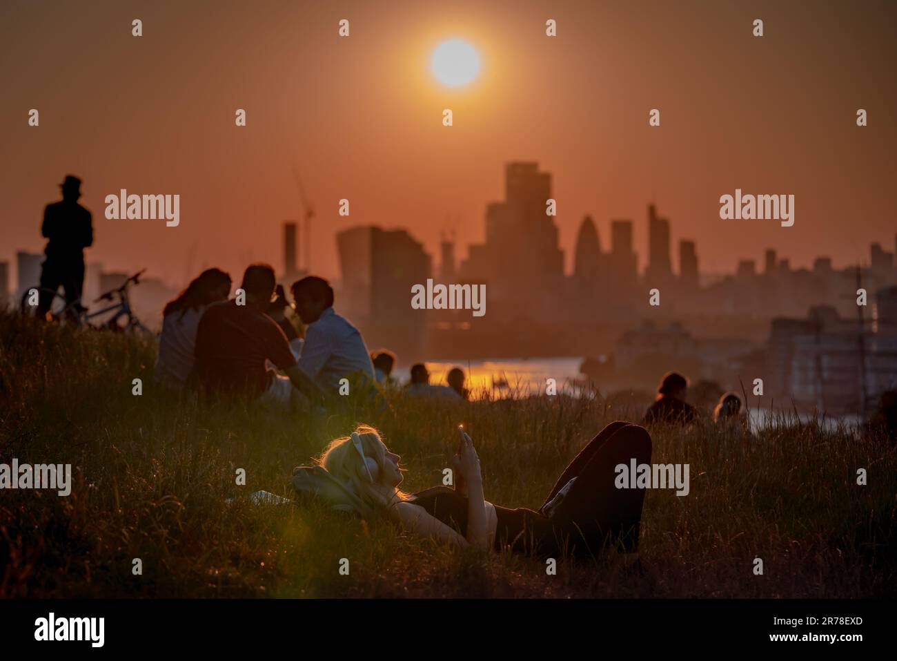 London, UK. 13th June, 2023. UK Weather: A young women relaxes with a ...