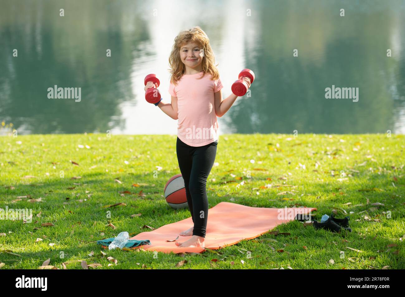 Child boy working out with dumbbells on park background. Kids sport ...